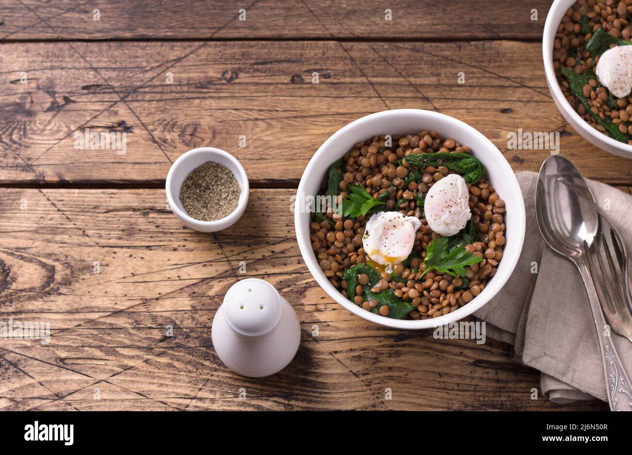 Boiled lentils with spinach, herbs, spices and poached egg in ceramic ...