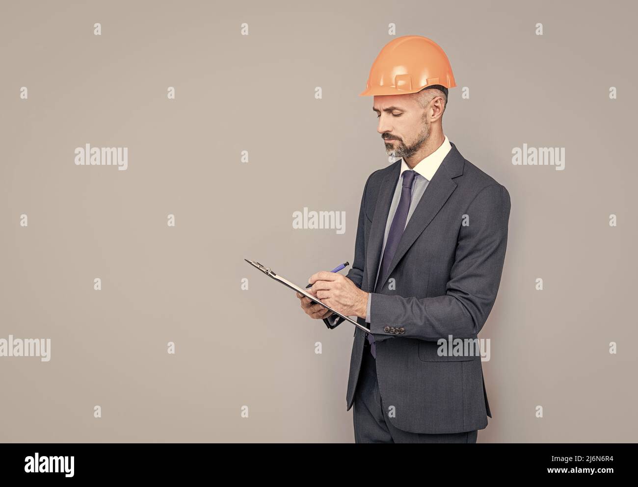 safety business expertise. successful man in hardhat making notes ...