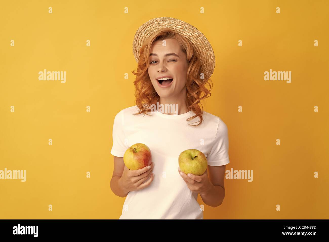 happy winking redhead woman in straw hat hold apple, lunch break Stock ...