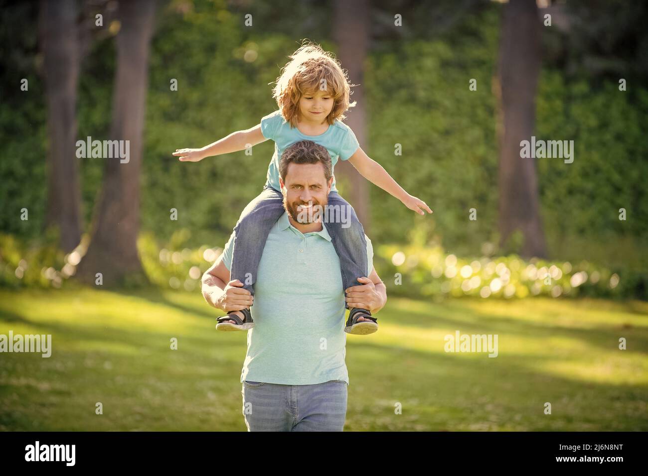 Ill give a piggy-back ride. Happy man carry son sitting on shoulders. Happy kid ride piggy-back ...