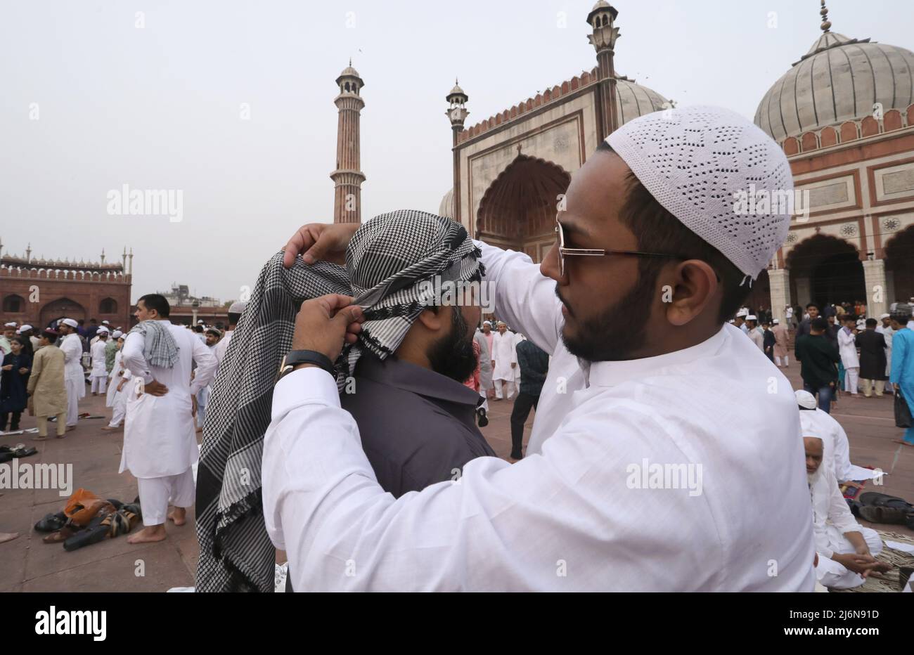 A Muslim man ties an Islamic headwrap scarf (prayer scarf) after ...