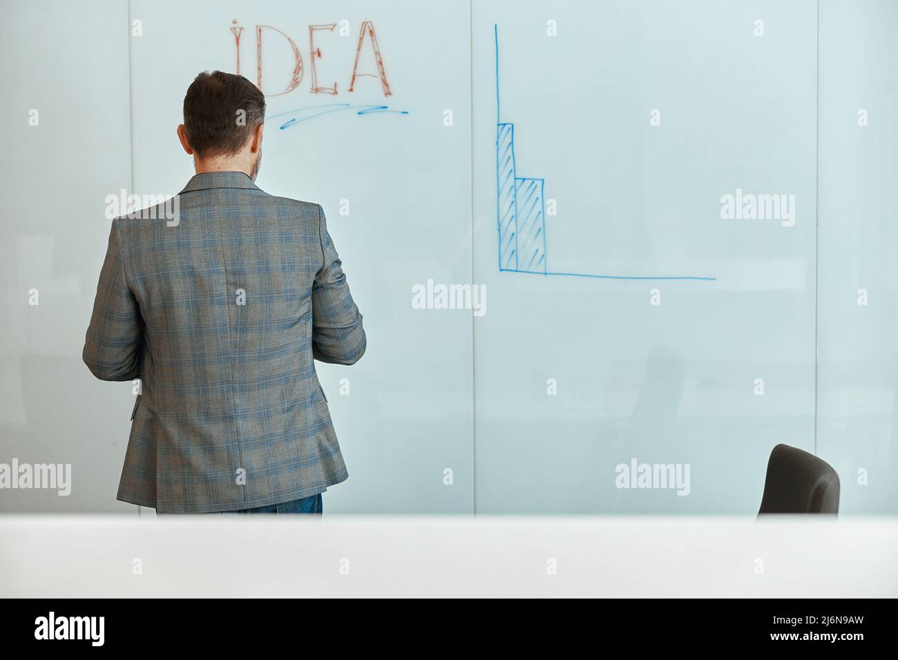 Back view of man standing opposite the white board Stock Photo - Alamy