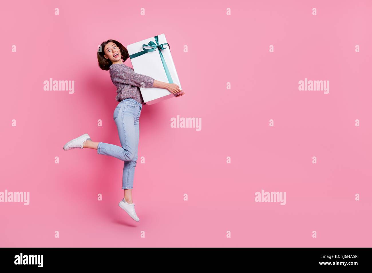 Full length body size view of attractive cheerful girl jumping holding ...