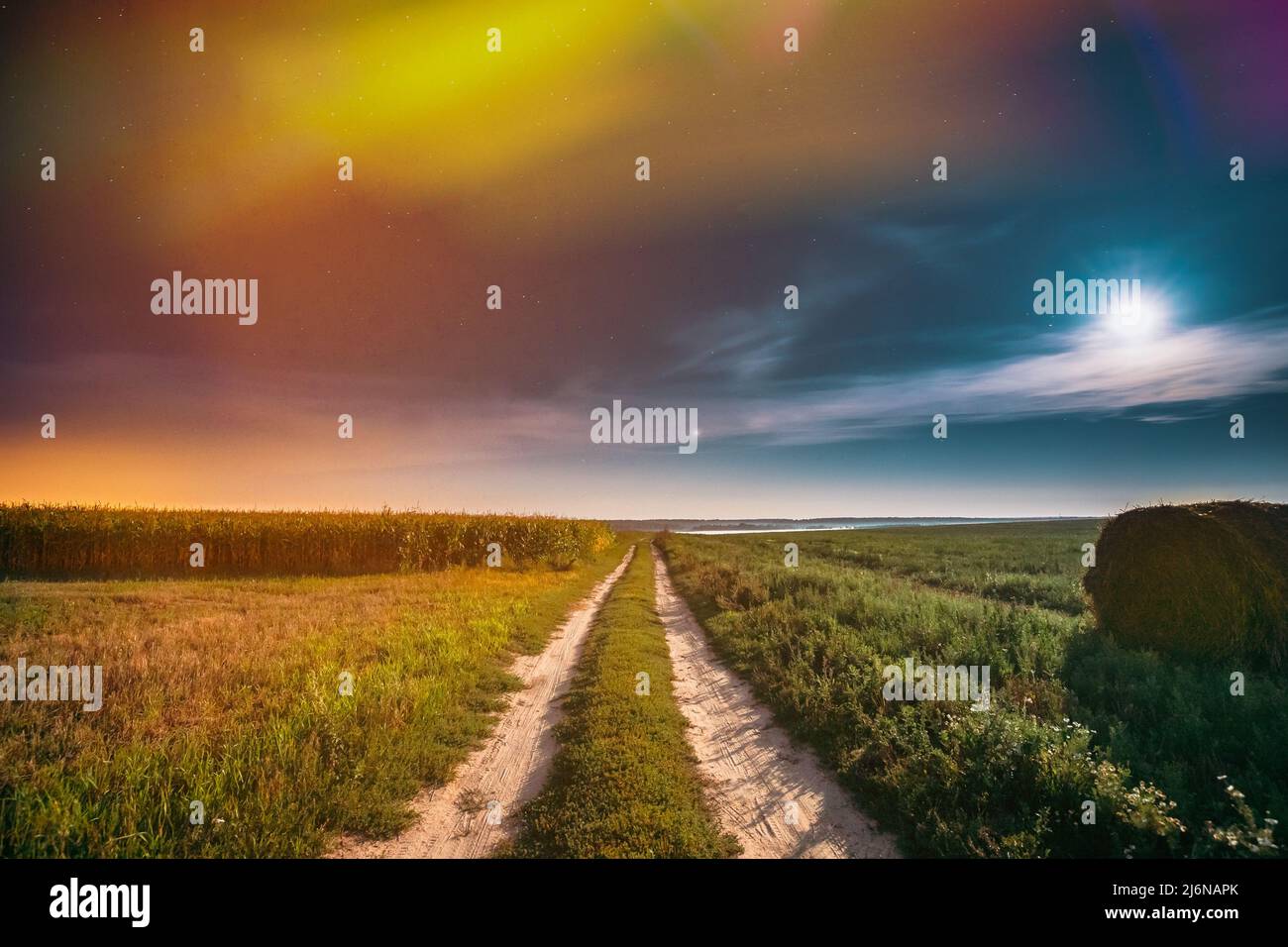 Night Starry Sky Above Country road through Field Meadow With Hay Bale ...