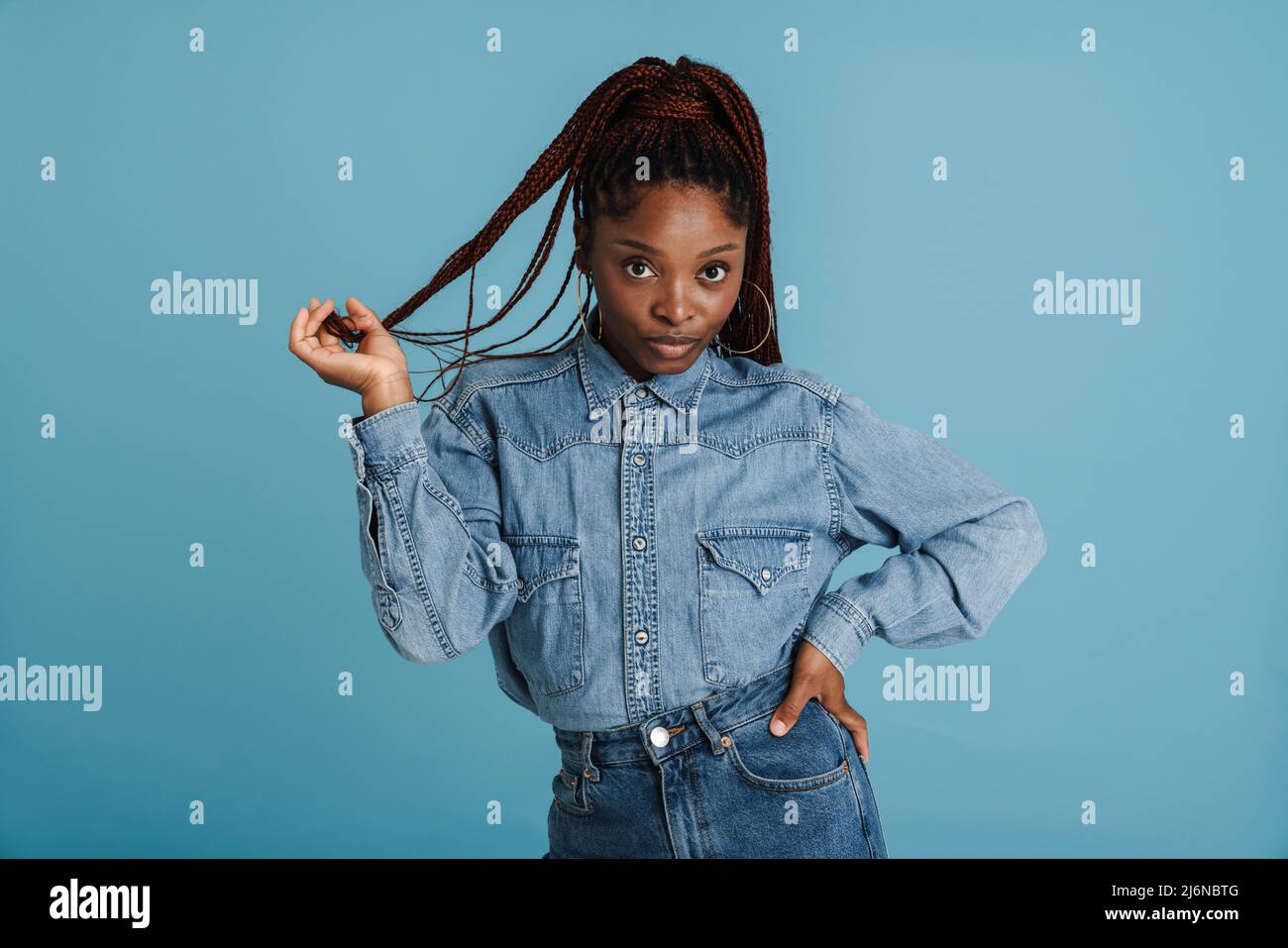 Young black woman with afro pigtails posing and looking at camera ...