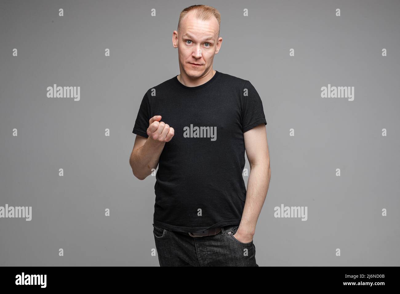 Man showing fist with serious face Stock Photo - Alamy
