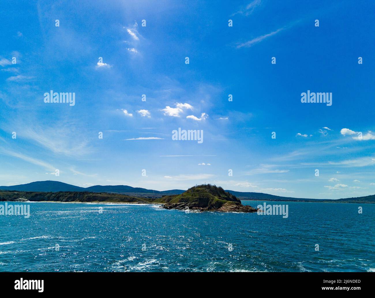 Panorama of a wild stone and sandy beach with dark wet sea sand and ...