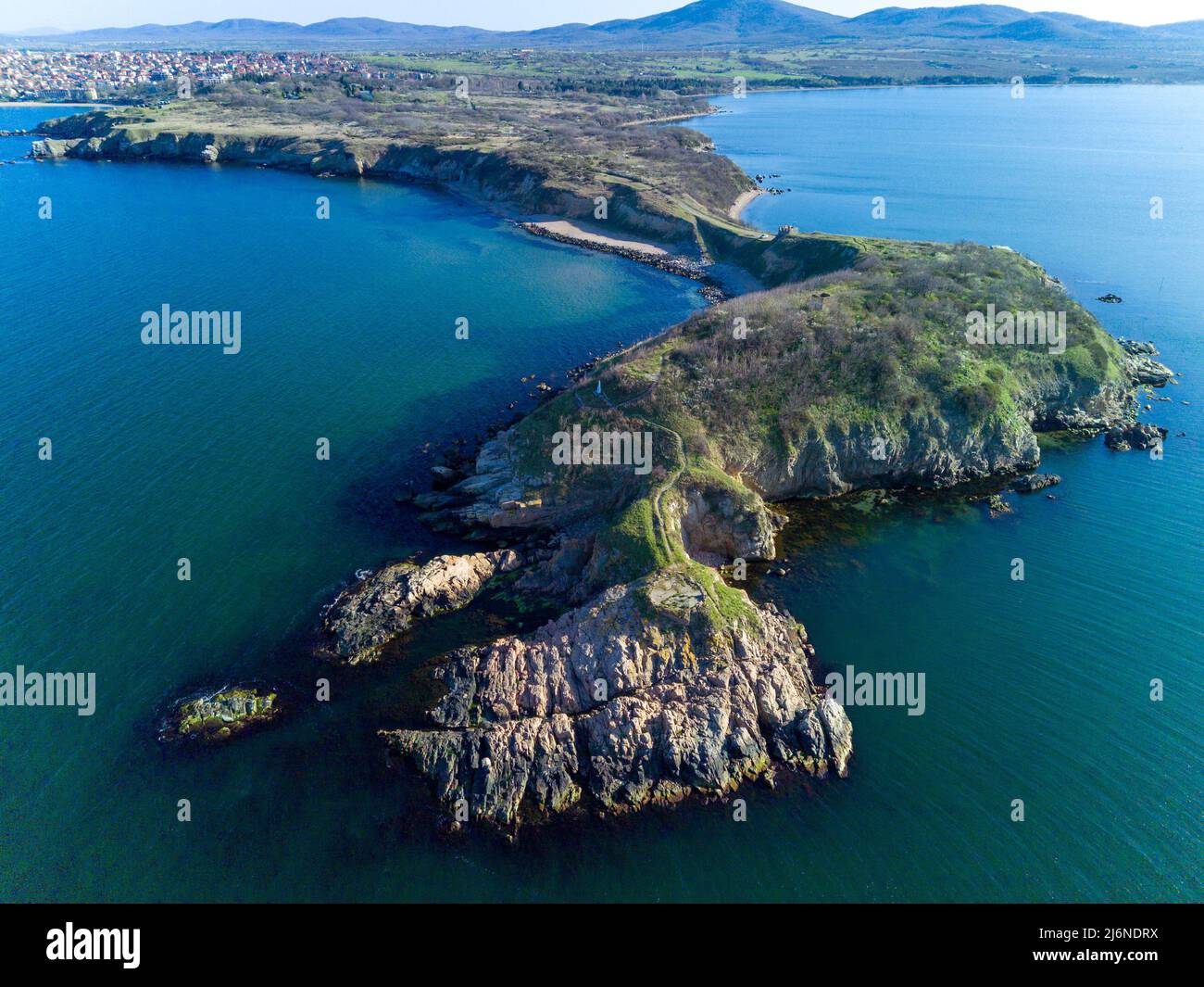 Panorama of a wild stone and sandy beach with dark wet sea sand and ...