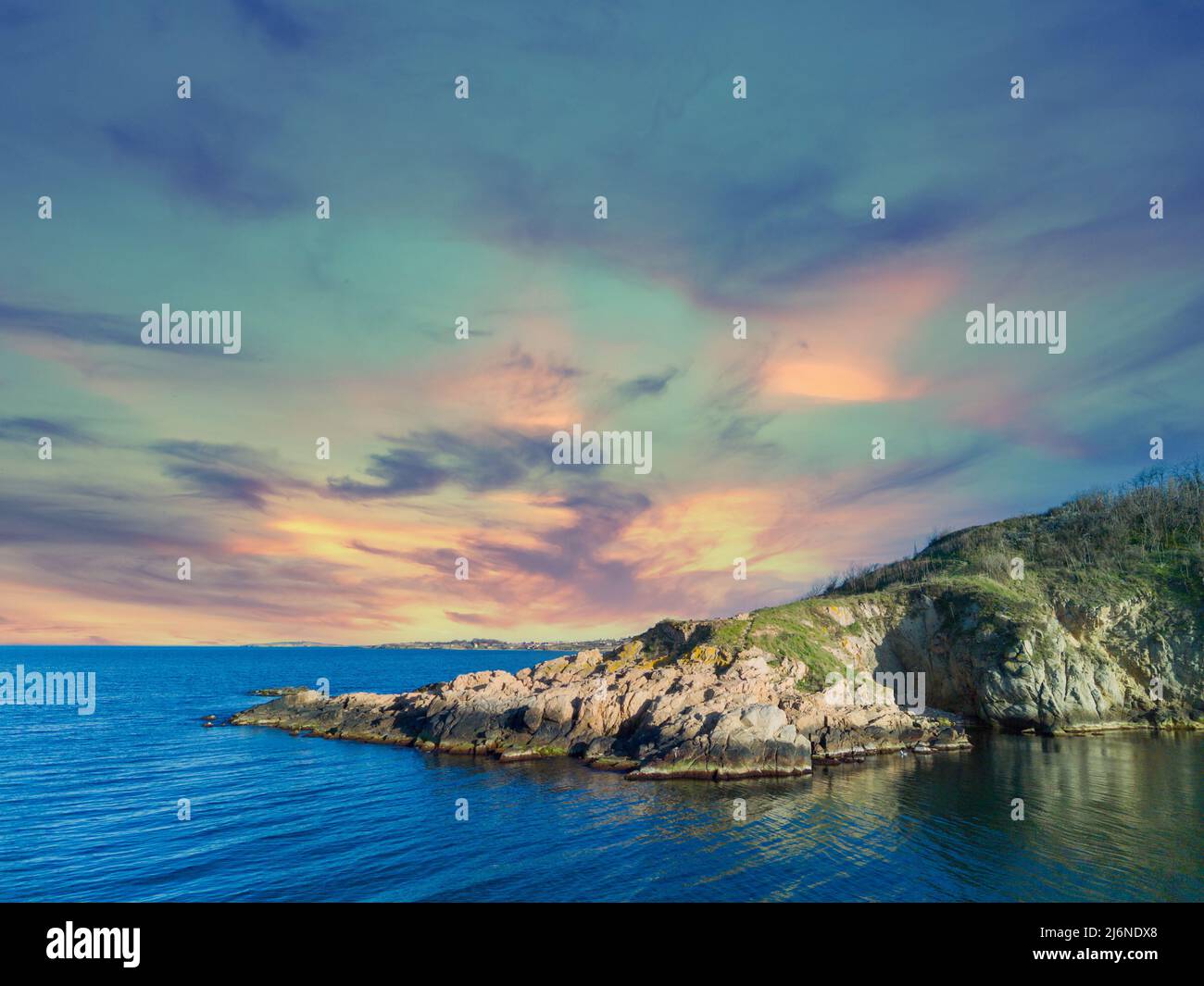 Panorama of a wild stone and sandy beach with dark wet sea sand and ...