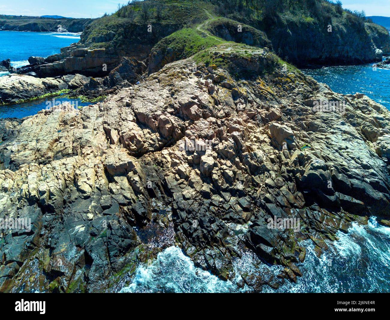 Panorama of a wild stone and sandy beach with dark wet sea sand and ...