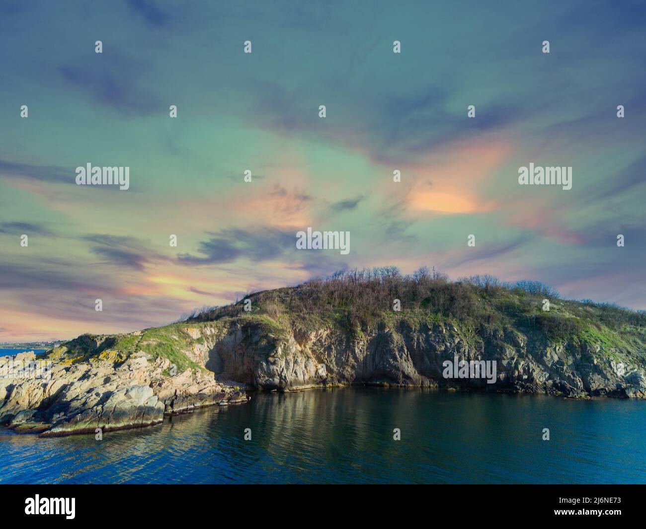 Panorama of a wild stone and sandy beach with dark wet sea sand and ...