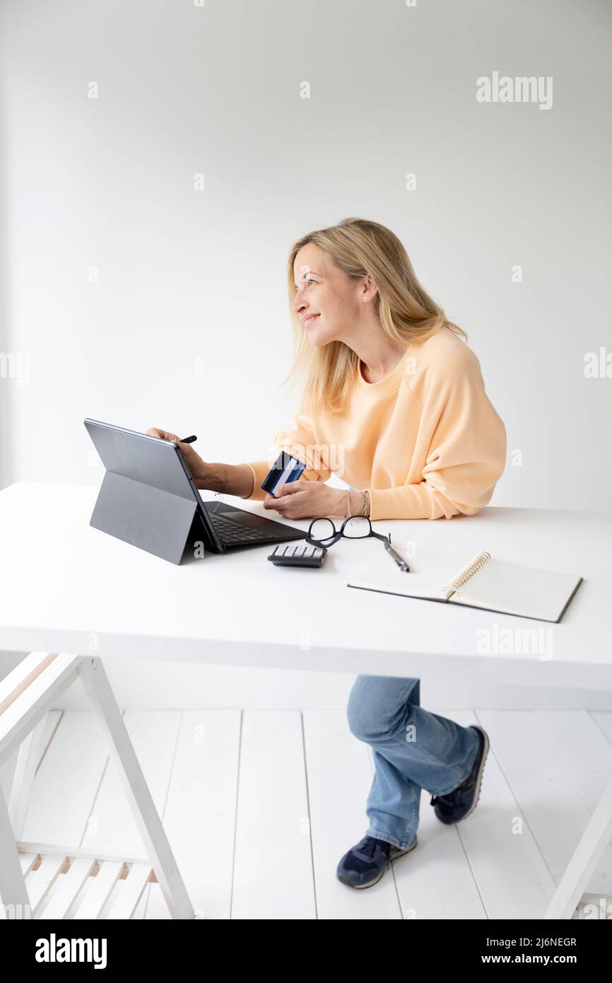 pretty young woman standing by height adjustable table ordering things ...