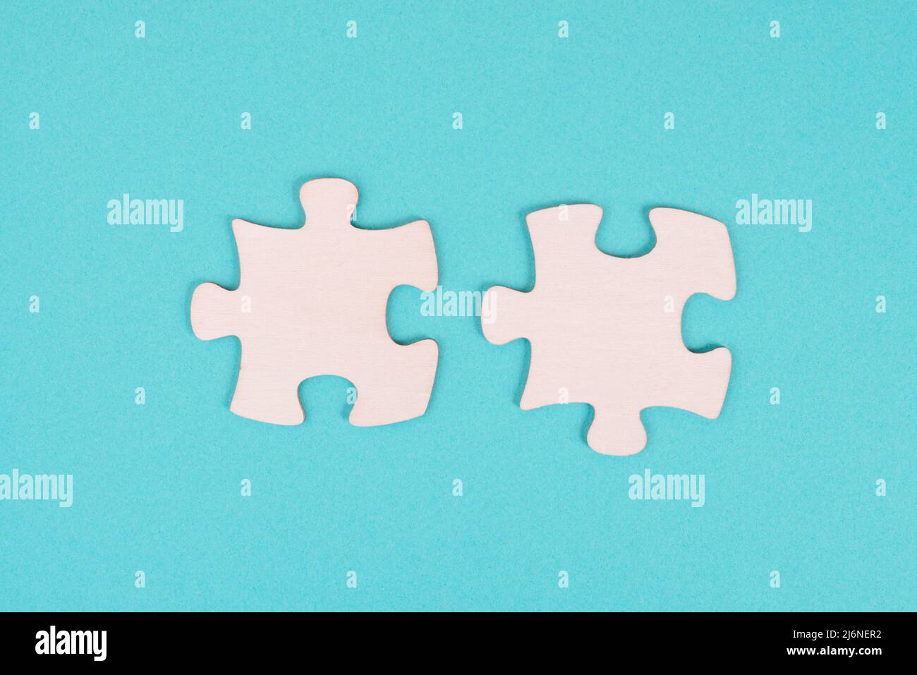 Two pieces of a puzzle, connecting together as a team, solving a ...