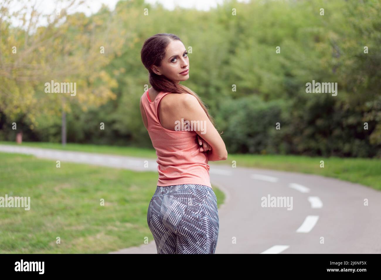 Beautiful athletic woman standing running track in summer park Portrait ...