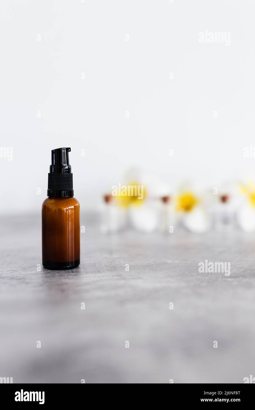 amber skincare bottle with flowers in the background, concept of ...