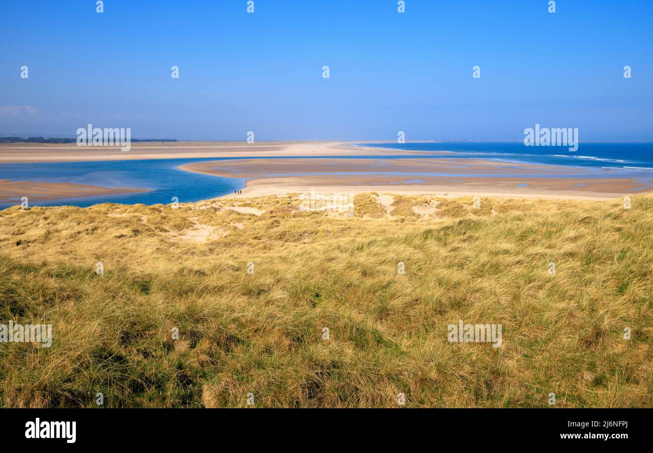 Across the sand dunes to Budle Water flowing into the North Sea at ...