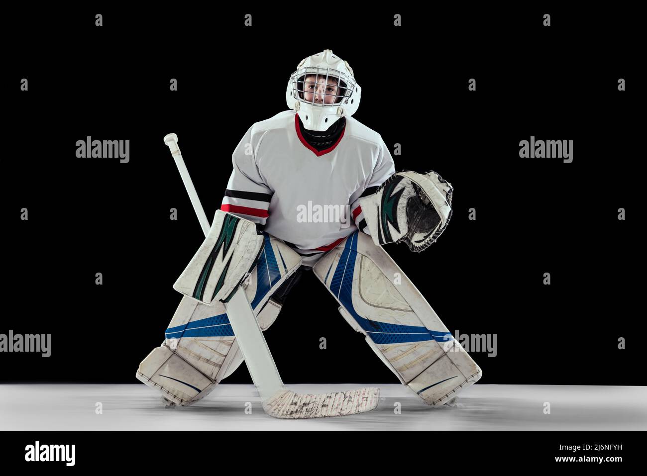Full-length portrait of boy, child playing hockey, training in ...