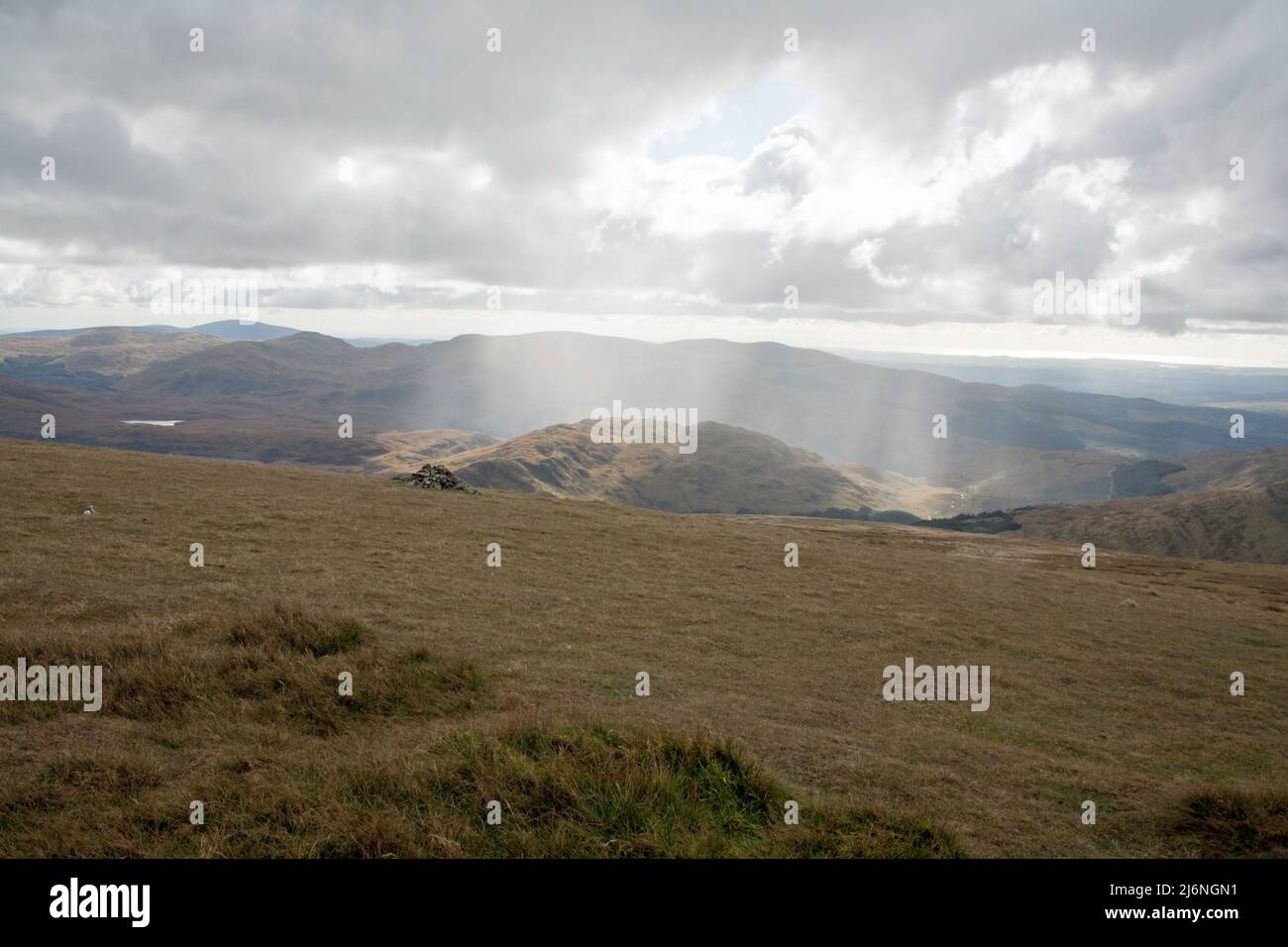 Shafts of sunlight breaking through the cloud the summit of Merrick ...