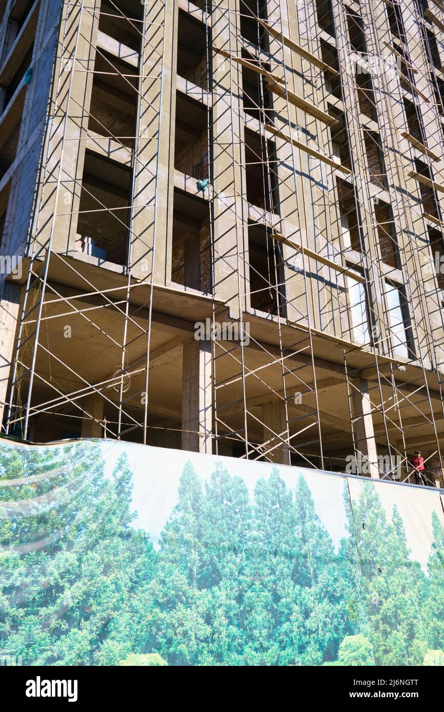 An office building under construction, with protective fence covered in ...