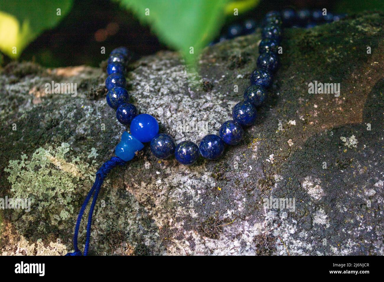 Close up of blue mala beads on stone. Buddhist prayer beads for japa ...