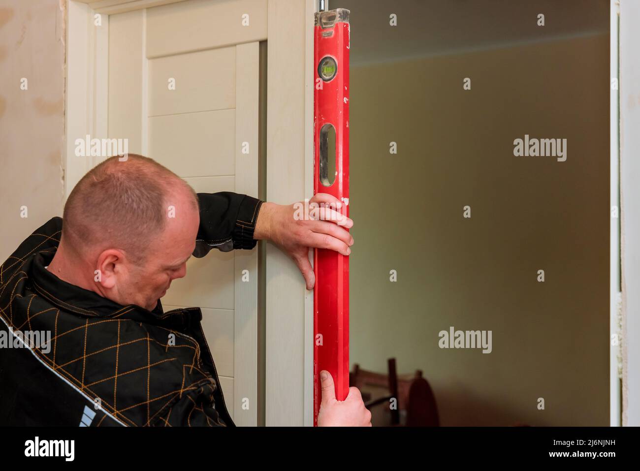 Man is installing the doors with checks level correctness installation ...
