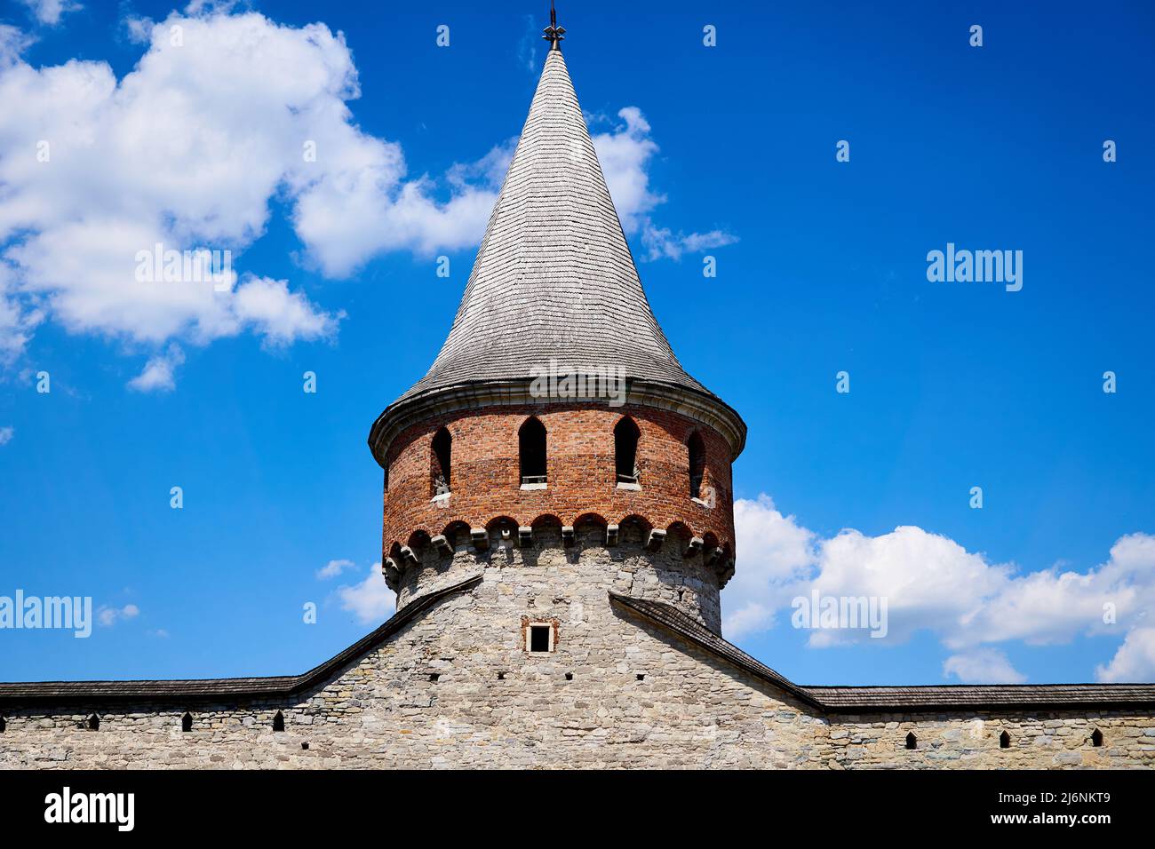 Watchtower of the old fortress wall in the summer expanse and blue sky ...