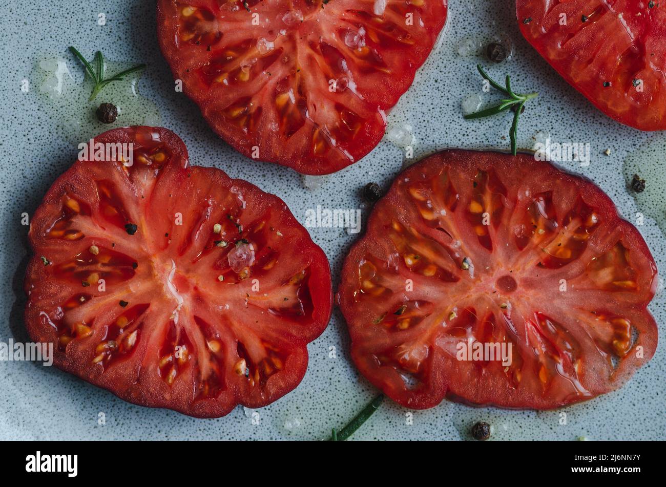 Macro photograph of blue sea tomato slices with dressing on a plate ...