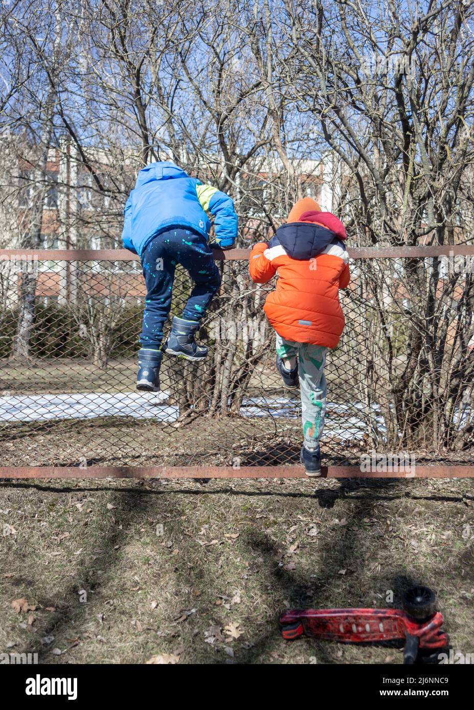 Two children climb over the fence. .Children's games Stock Photo - Alamy