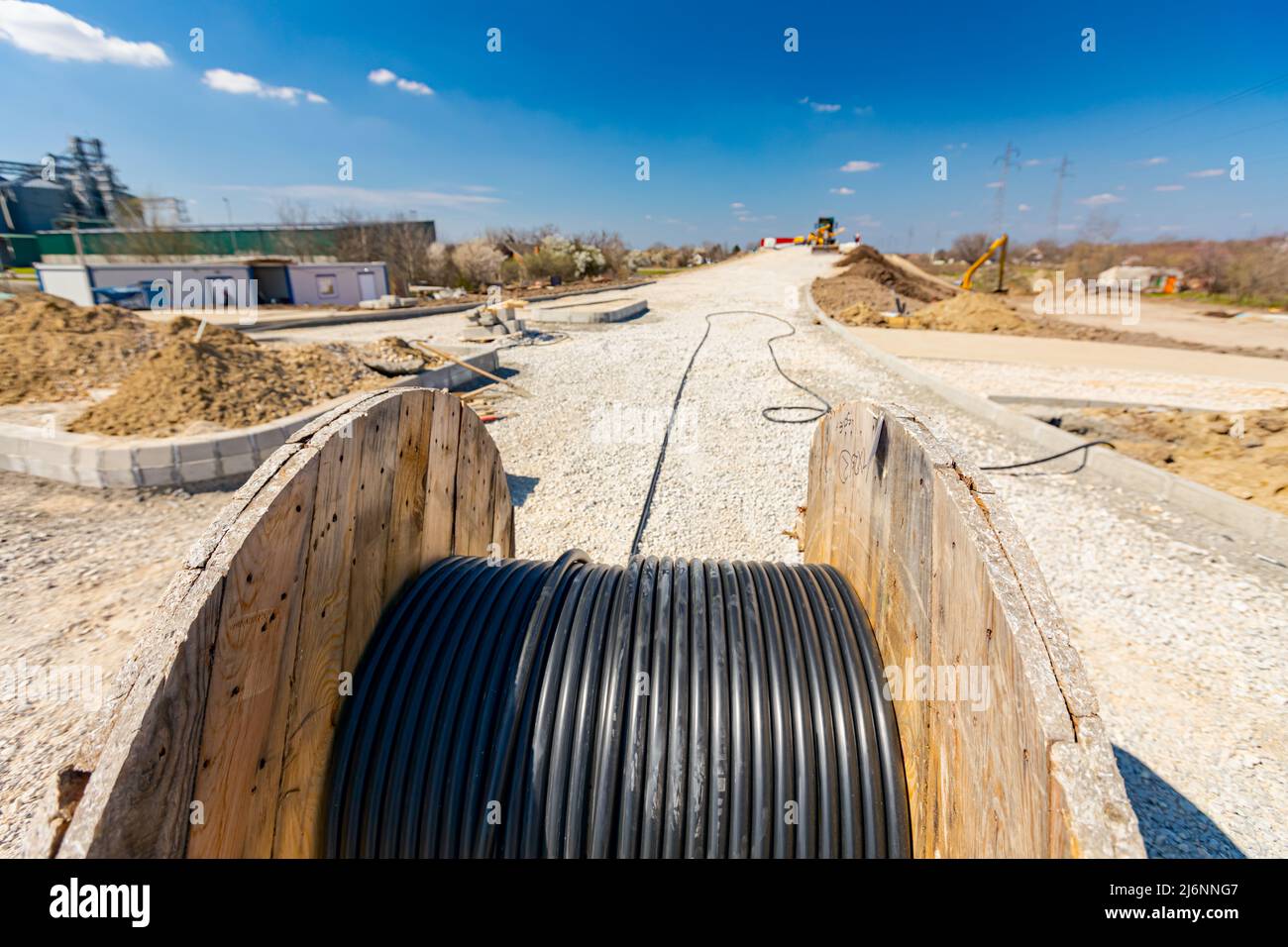Reel cable spool is on the wooden axle at building site Stock Photo - Alamy