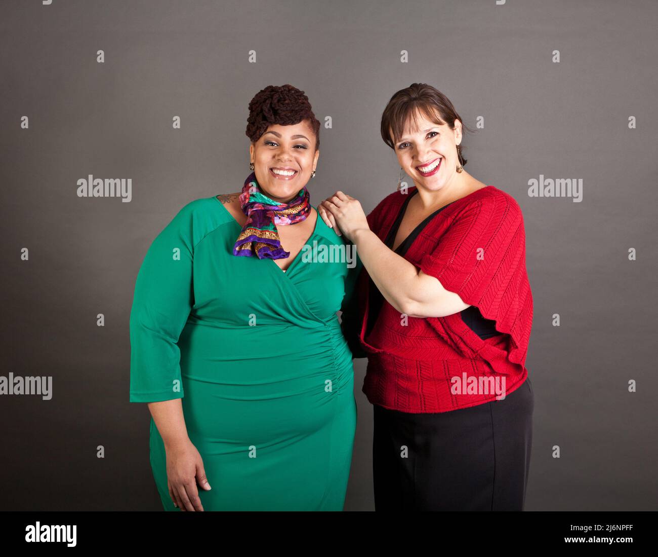 Happy, smiling plus size women of different races looking at the camera ...