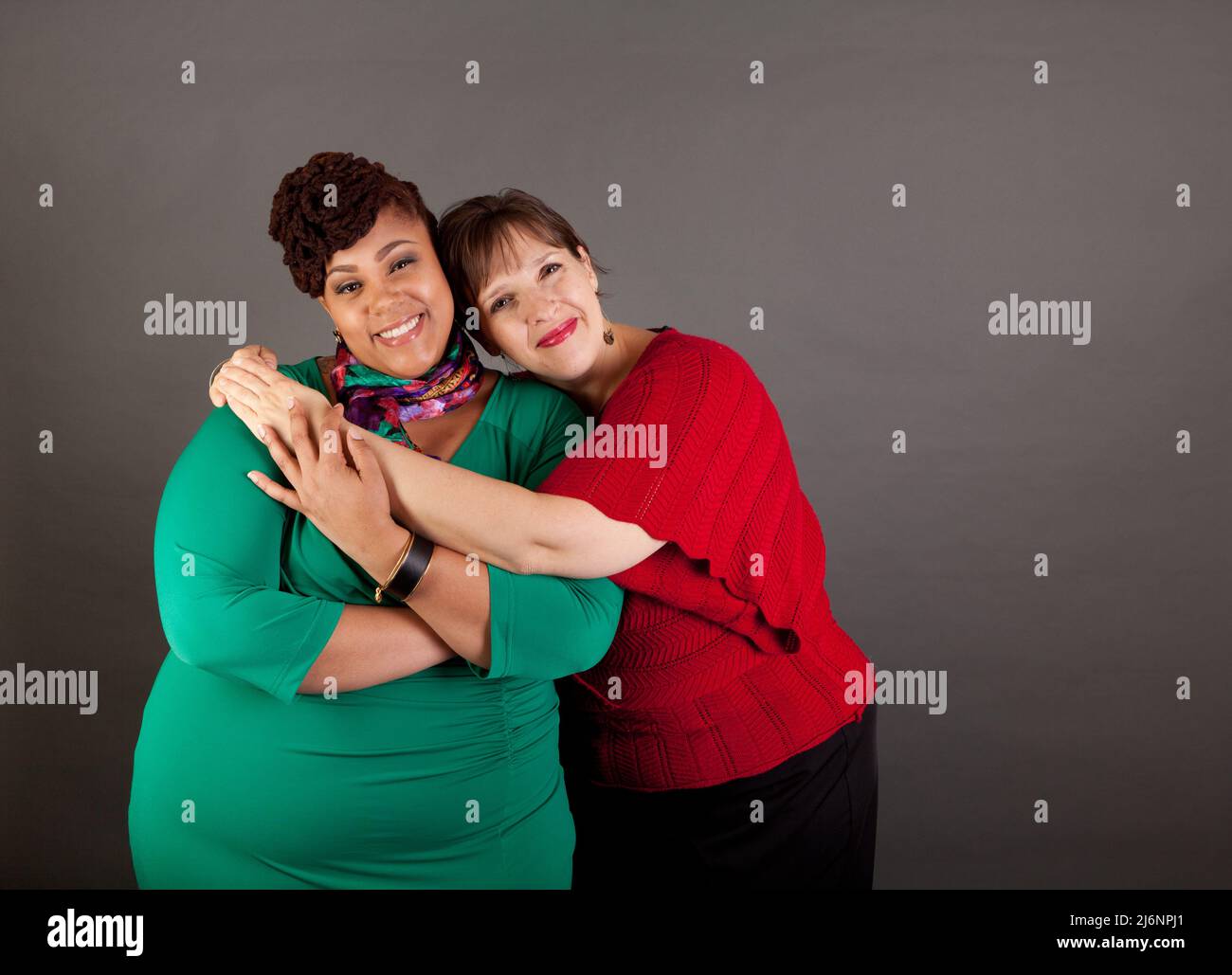 Happy, smiling plus size women of different races looking at the camera ...