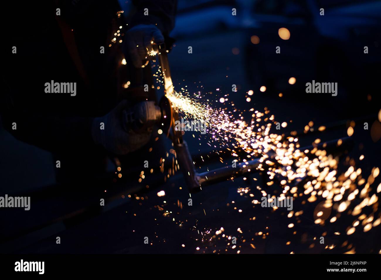 Sparks from grinding metal. Steel processing in workshop. Lights in ...