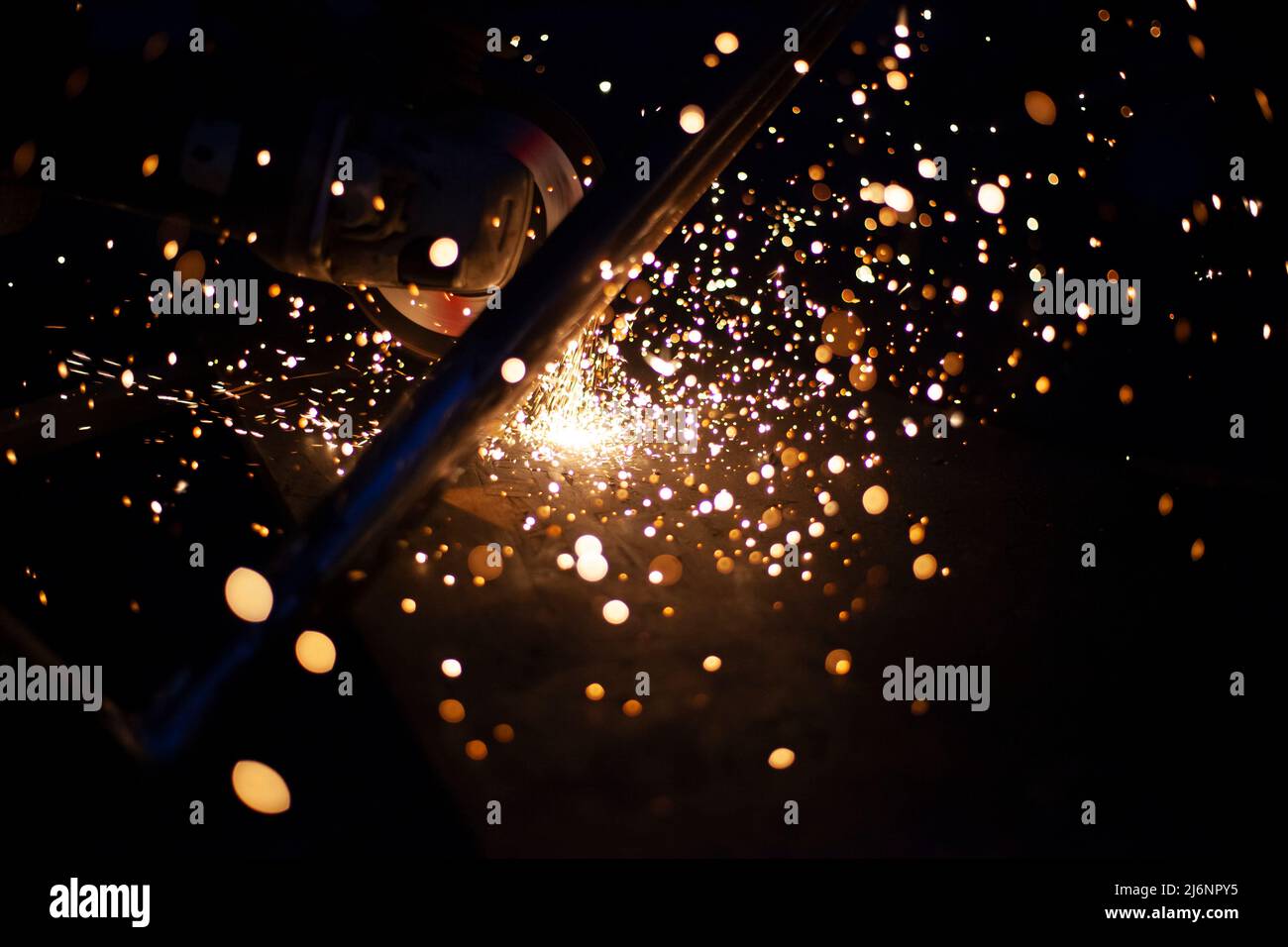Sparks from grinding metal. Steel processing in workshop. Lights in ...