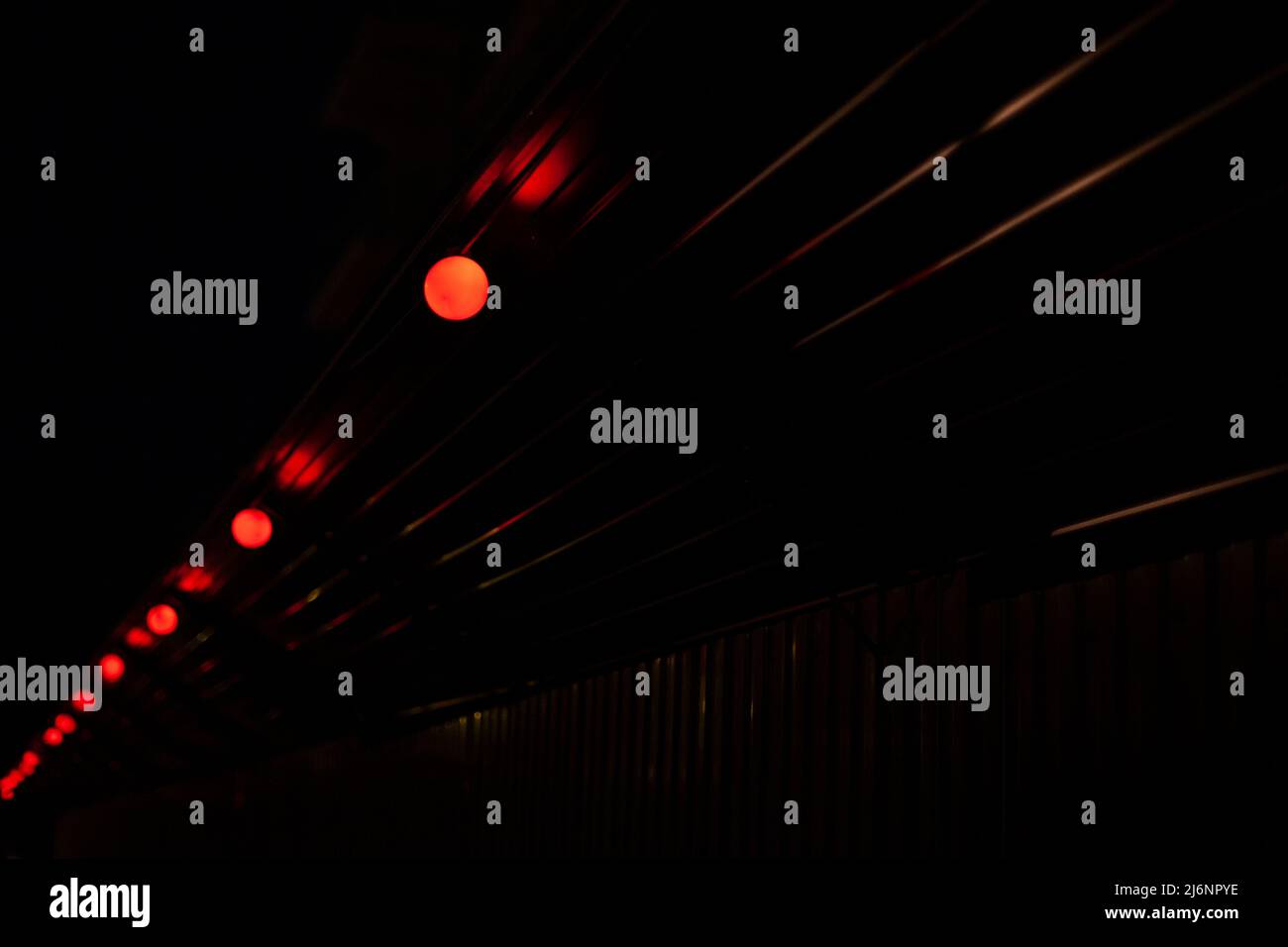 Signal lights on fence. Lamps shine red in dark. Fencing of ...