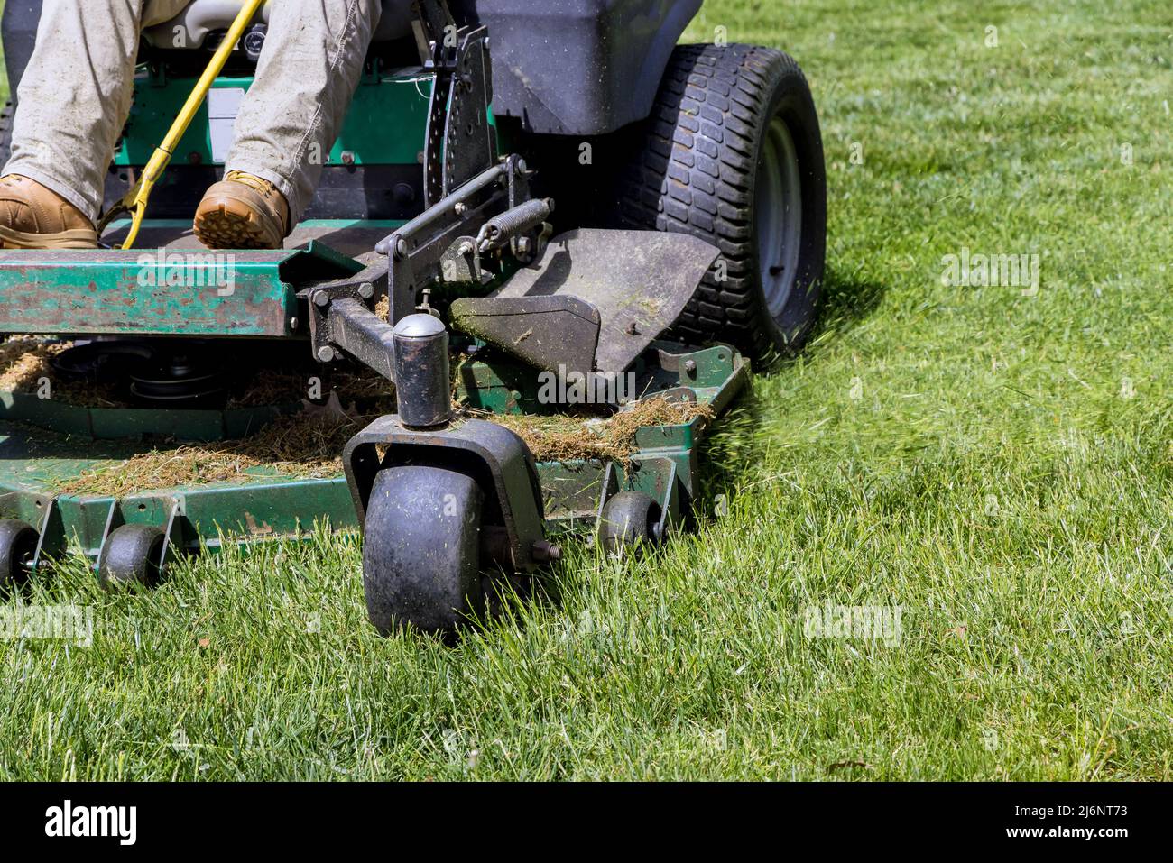 Man worker cutting grass with lawn mower Stock Photo - Alamy