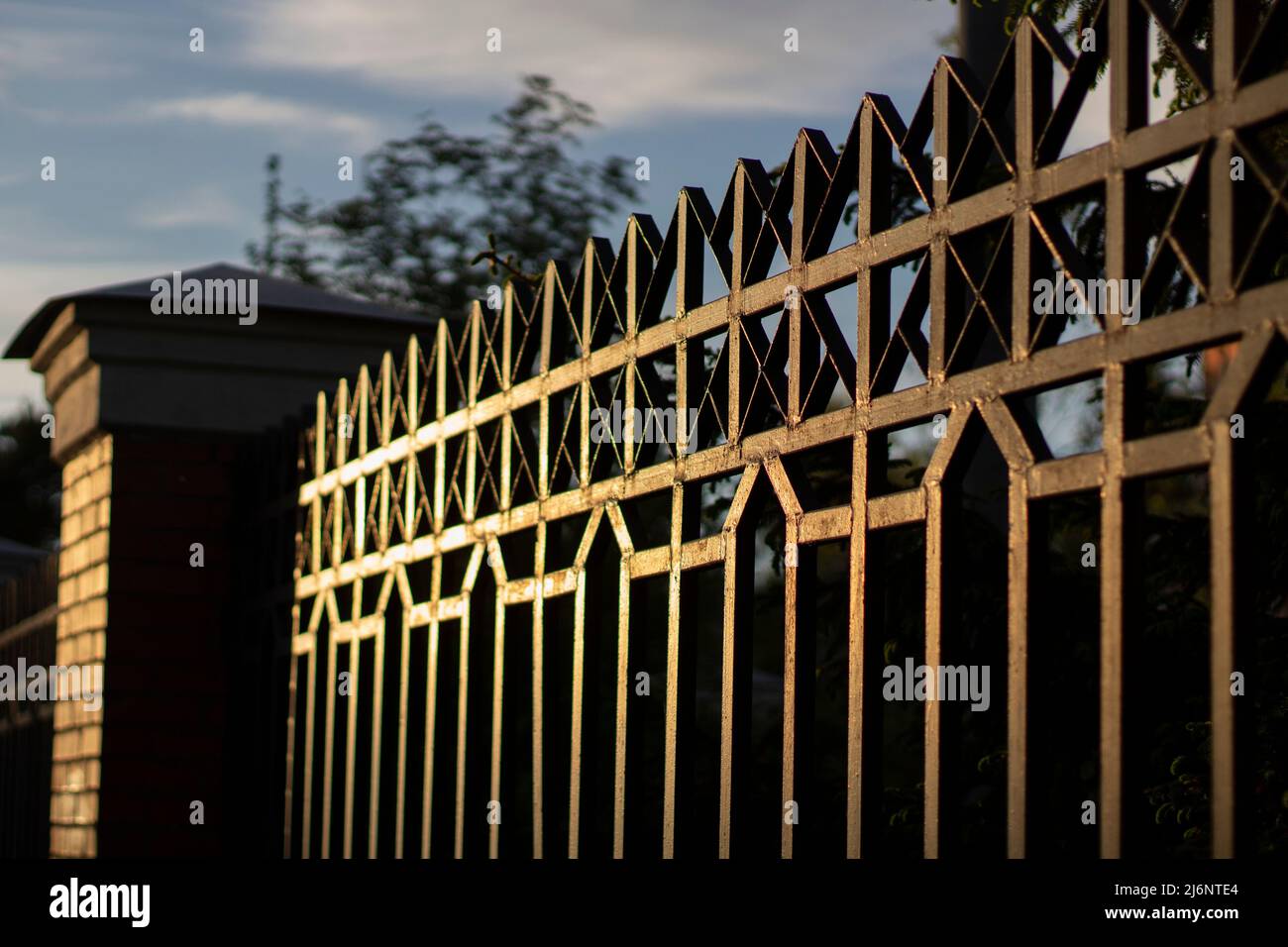 Fence in the sunlight. Metal forged fence. Fence made of steel. Light ...