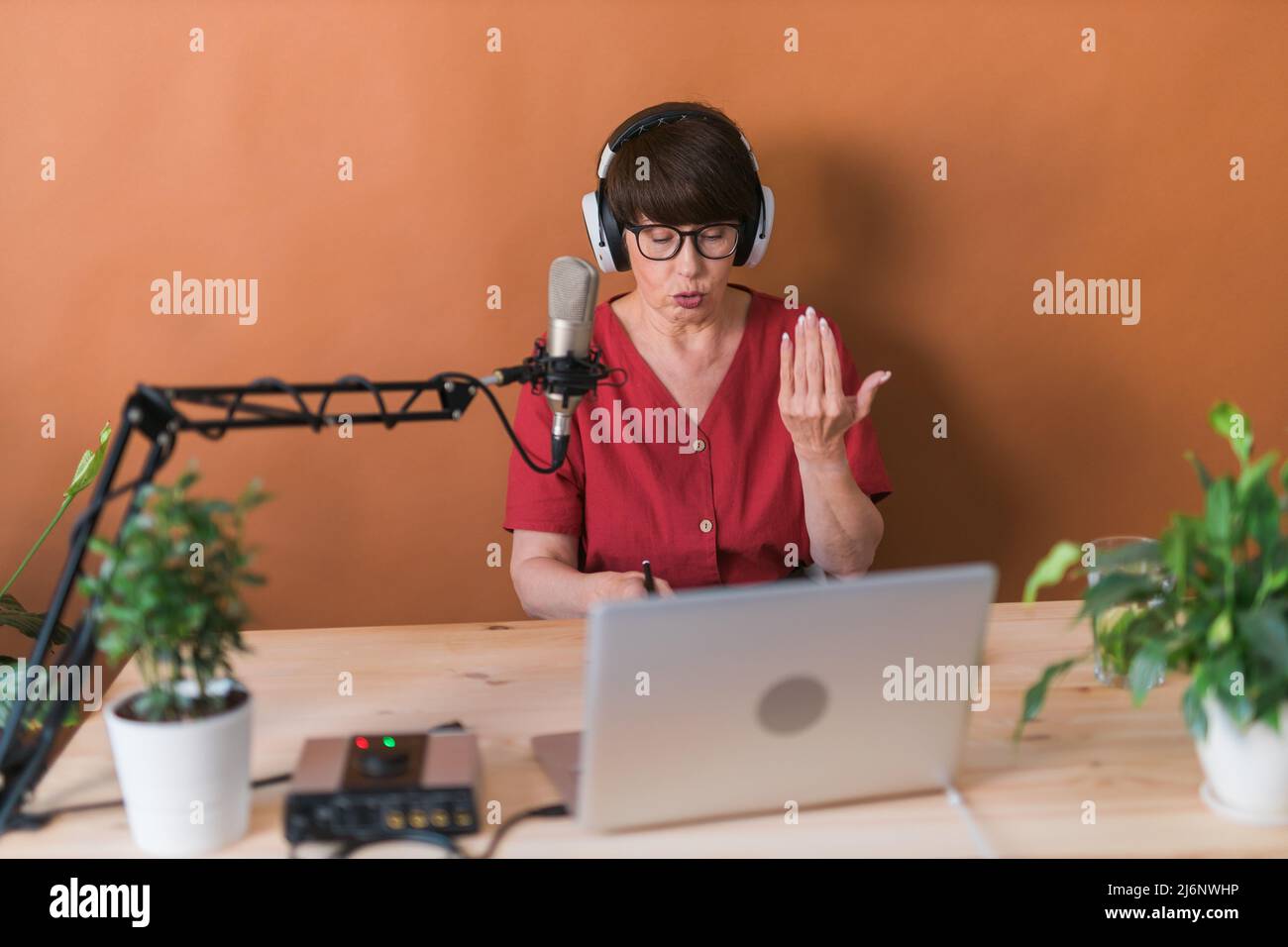 Middle-aged female radio presenter talking into the microphone and ...