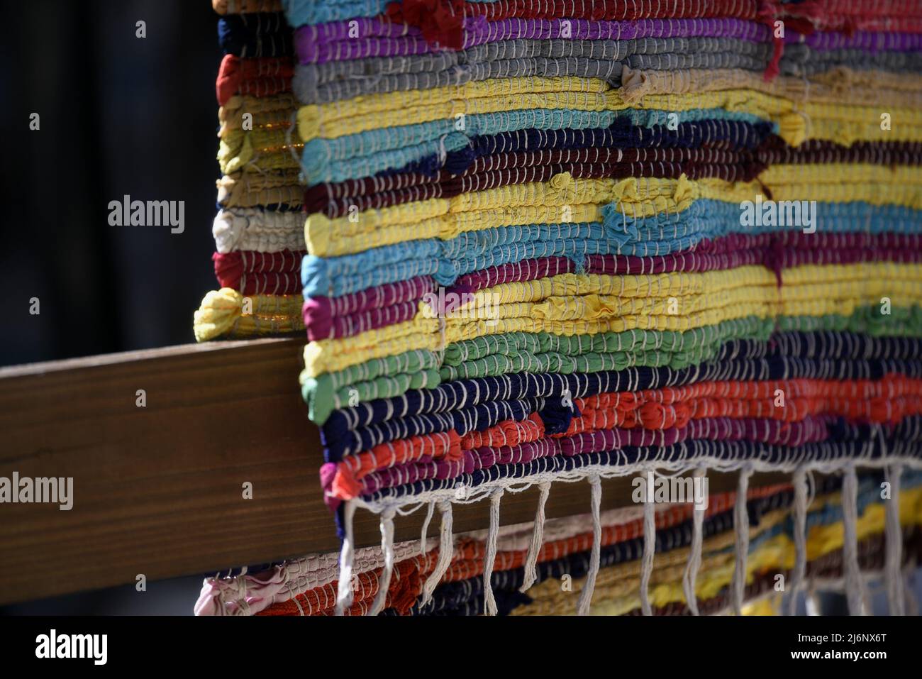 Traditional handwoven colorful kourelou rug hanging on a wooden fence ...