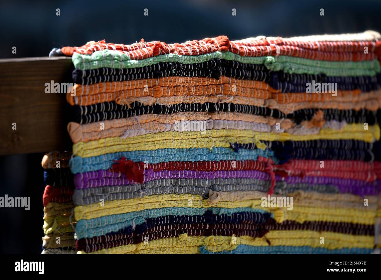 Traditional handwoven colorful kourelou rug hanging on a wooden fence ...