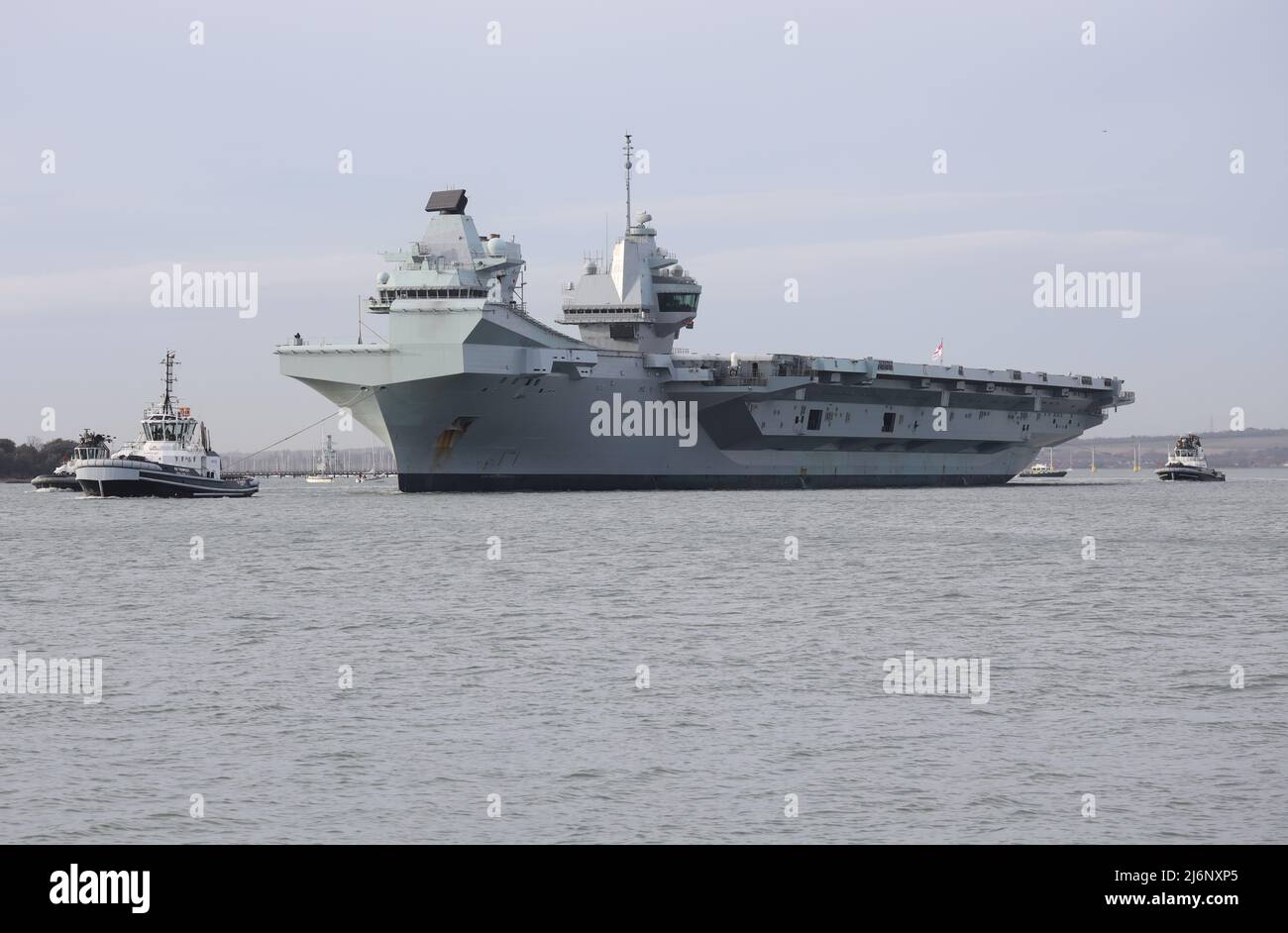 Tugs escort the Royal Navy aircraft carrier HMS QUEEN ELIZABETH out of ...