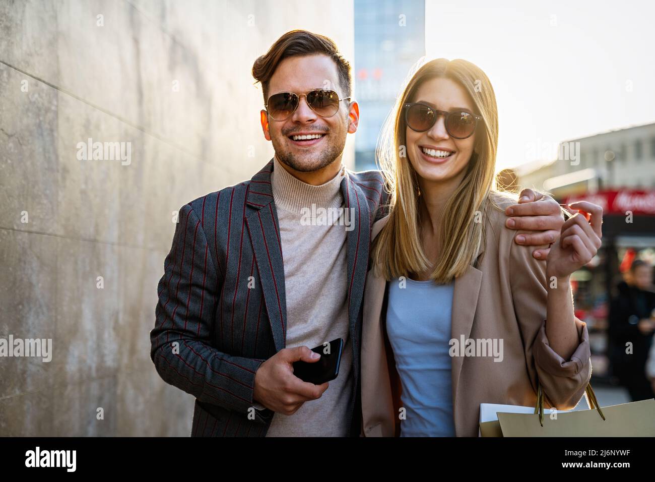 Beautiful young loving couple carrying shopping bags and enjoying ...