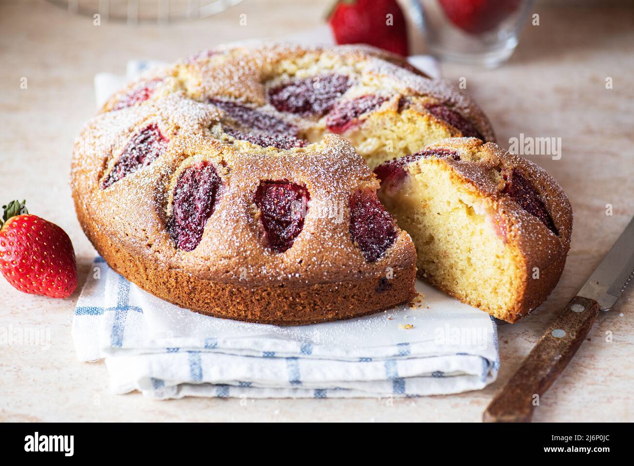 Sliced delicious strawberry one layer cake powdered with sugar. Close ...