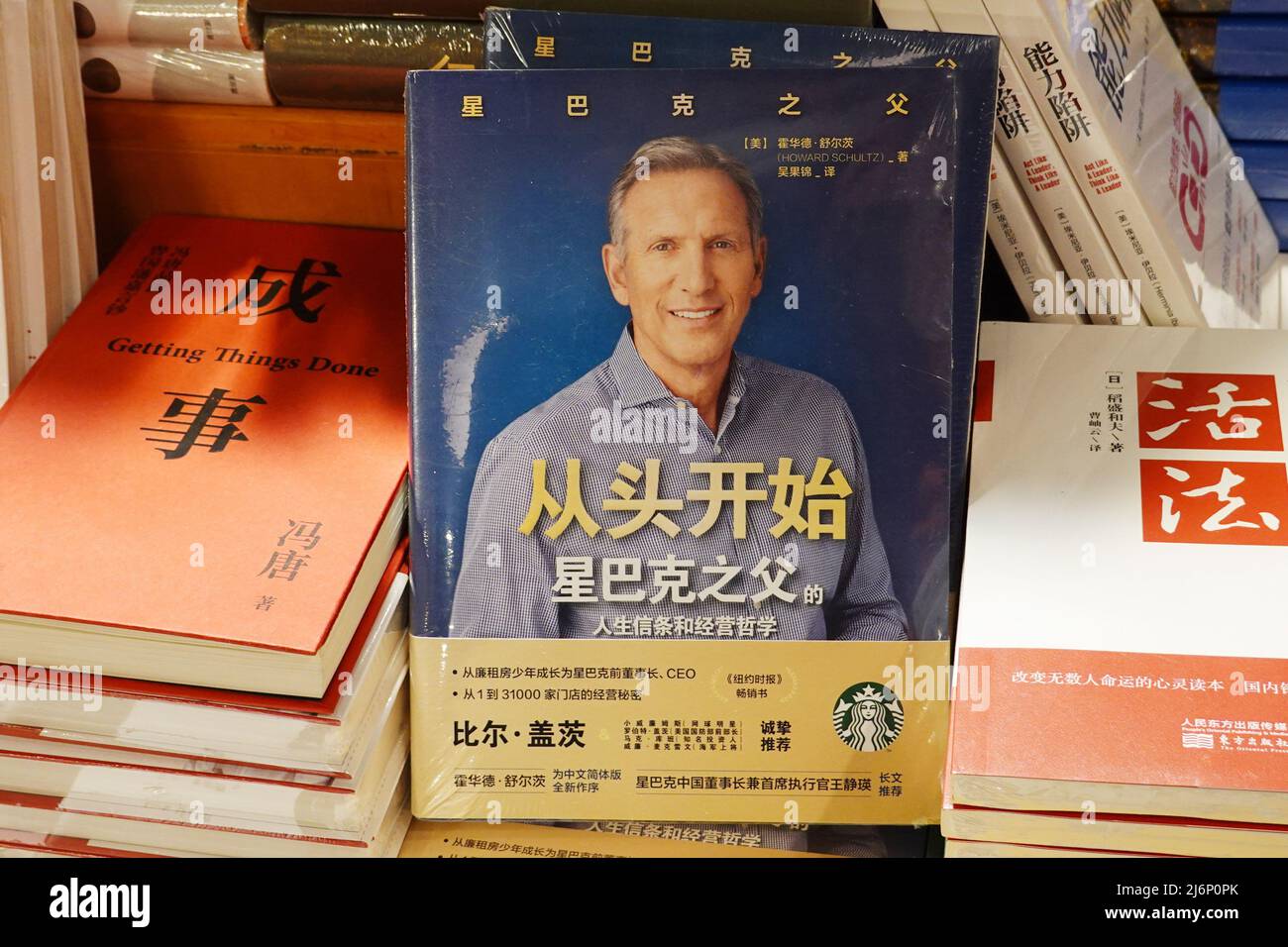 Starbucks CEO Howard D. Schultz is pictured on the cover of a book ...