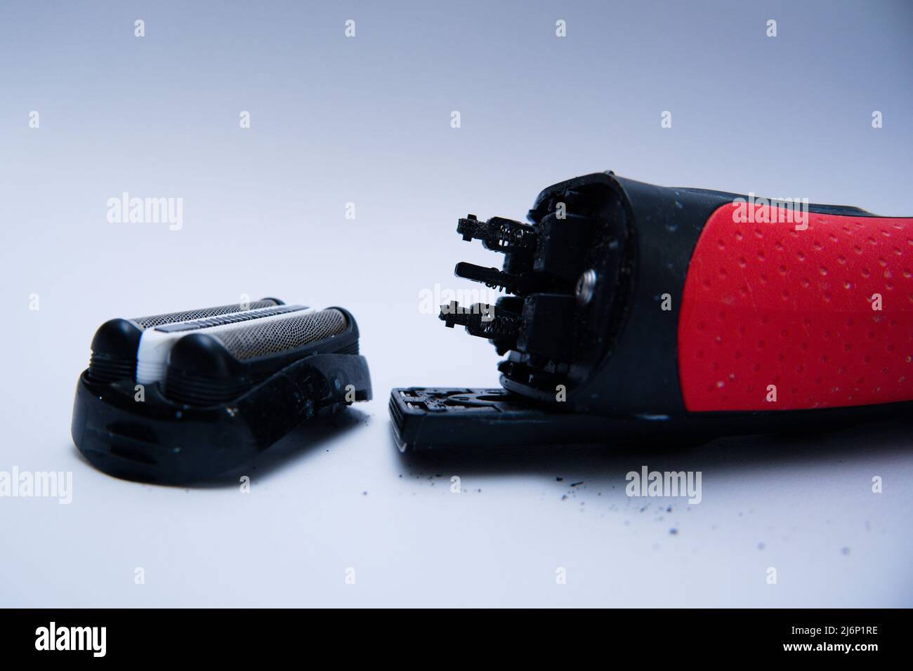 Disassemble a black and red shaver for cleaning Stock Photo - Alamy