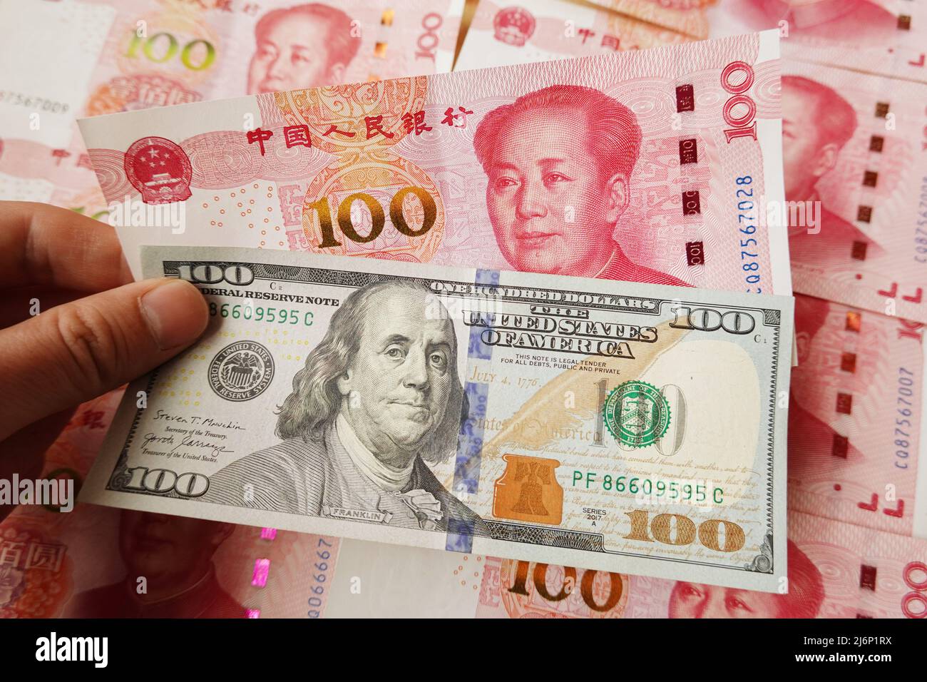 In this photo illustration, 100 US dollar notes and 100 RMB notes seen ...