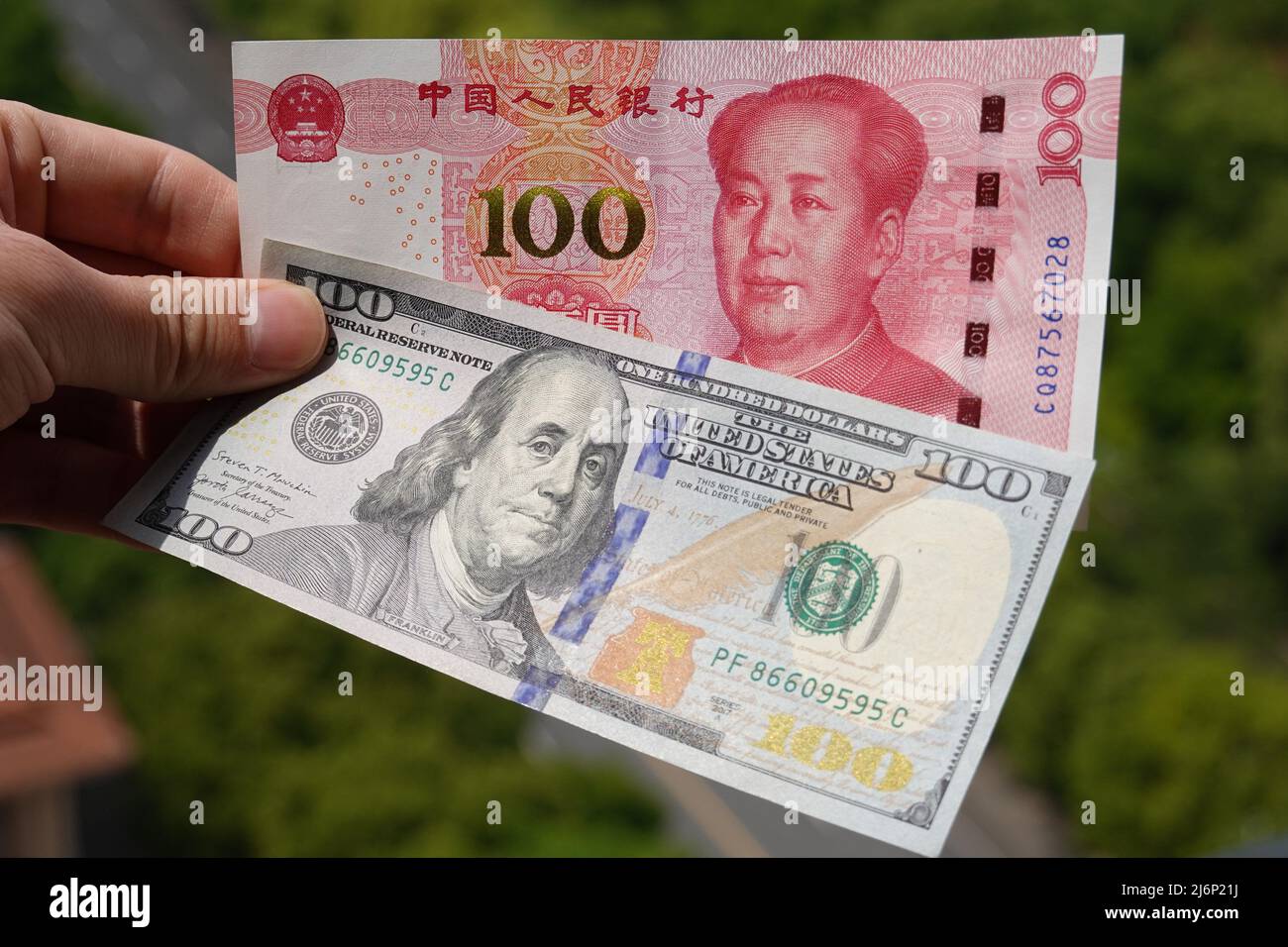In this photo illustration, 100 US dollar notes and 100 RMB notes seen ...