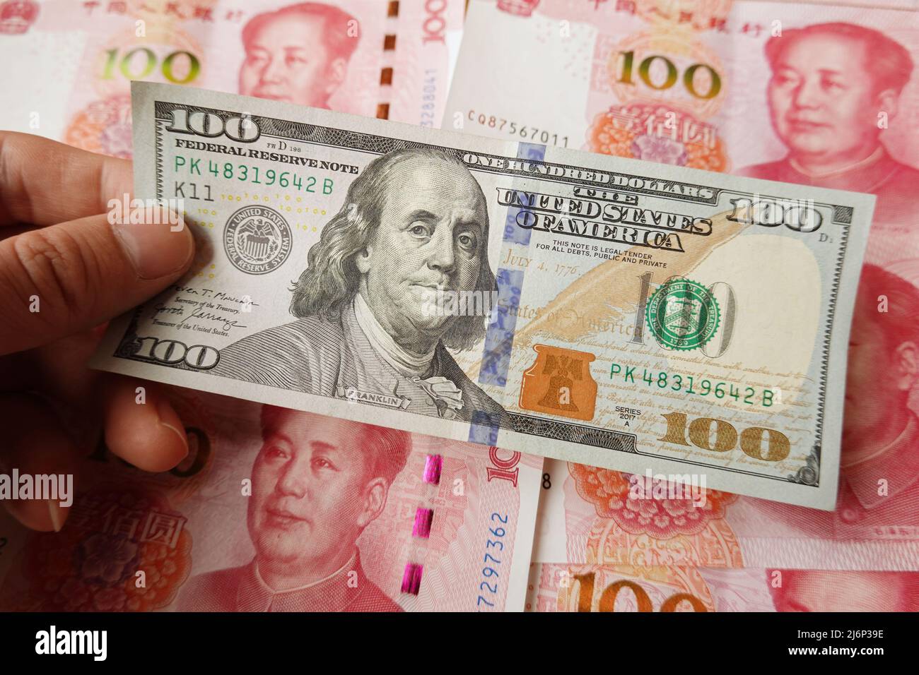 In this photo illustration, 100 US dollar notes and 100 RMB notes seen ...