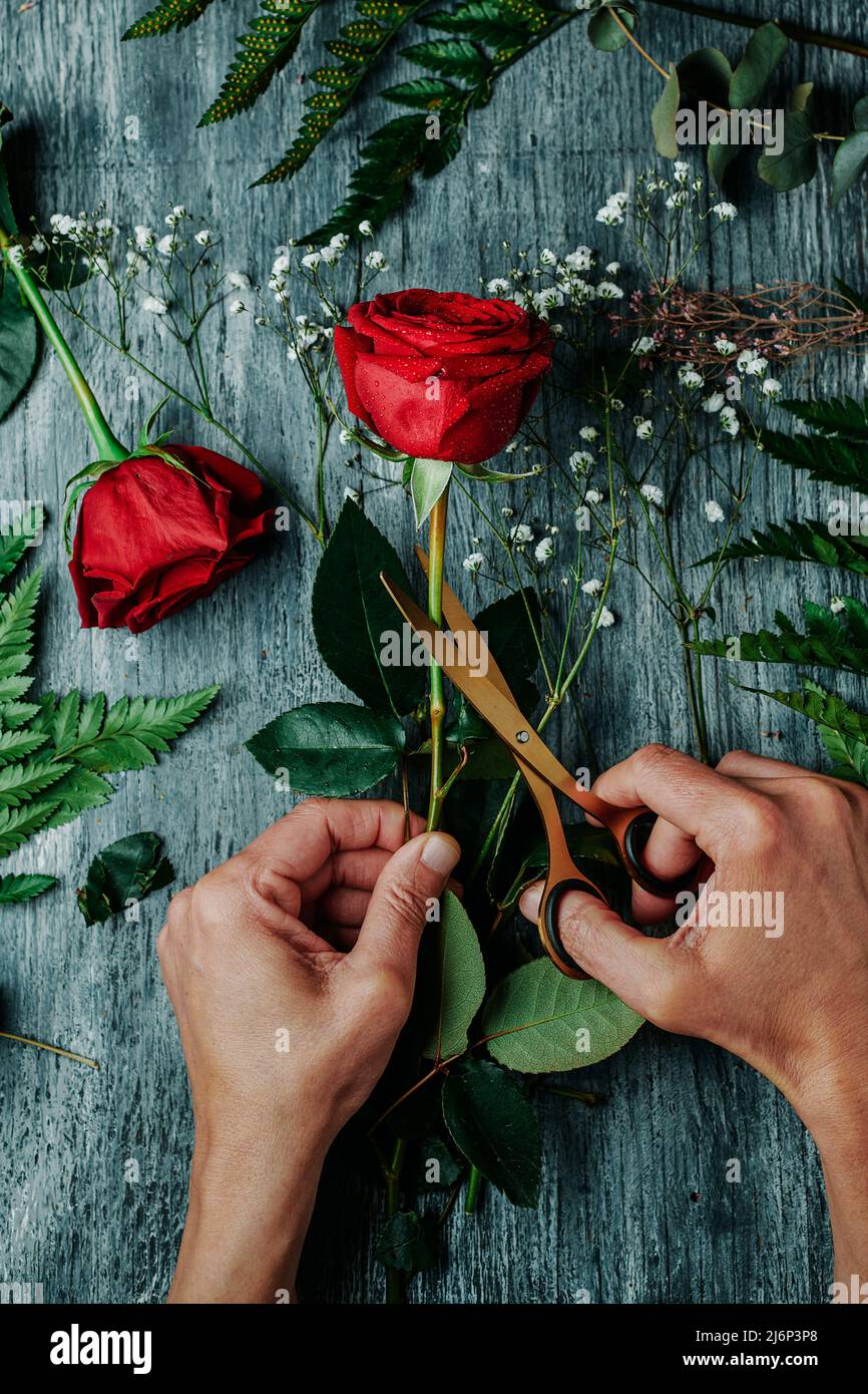 high angle view of a man using a pair of golden scissors to make a ...