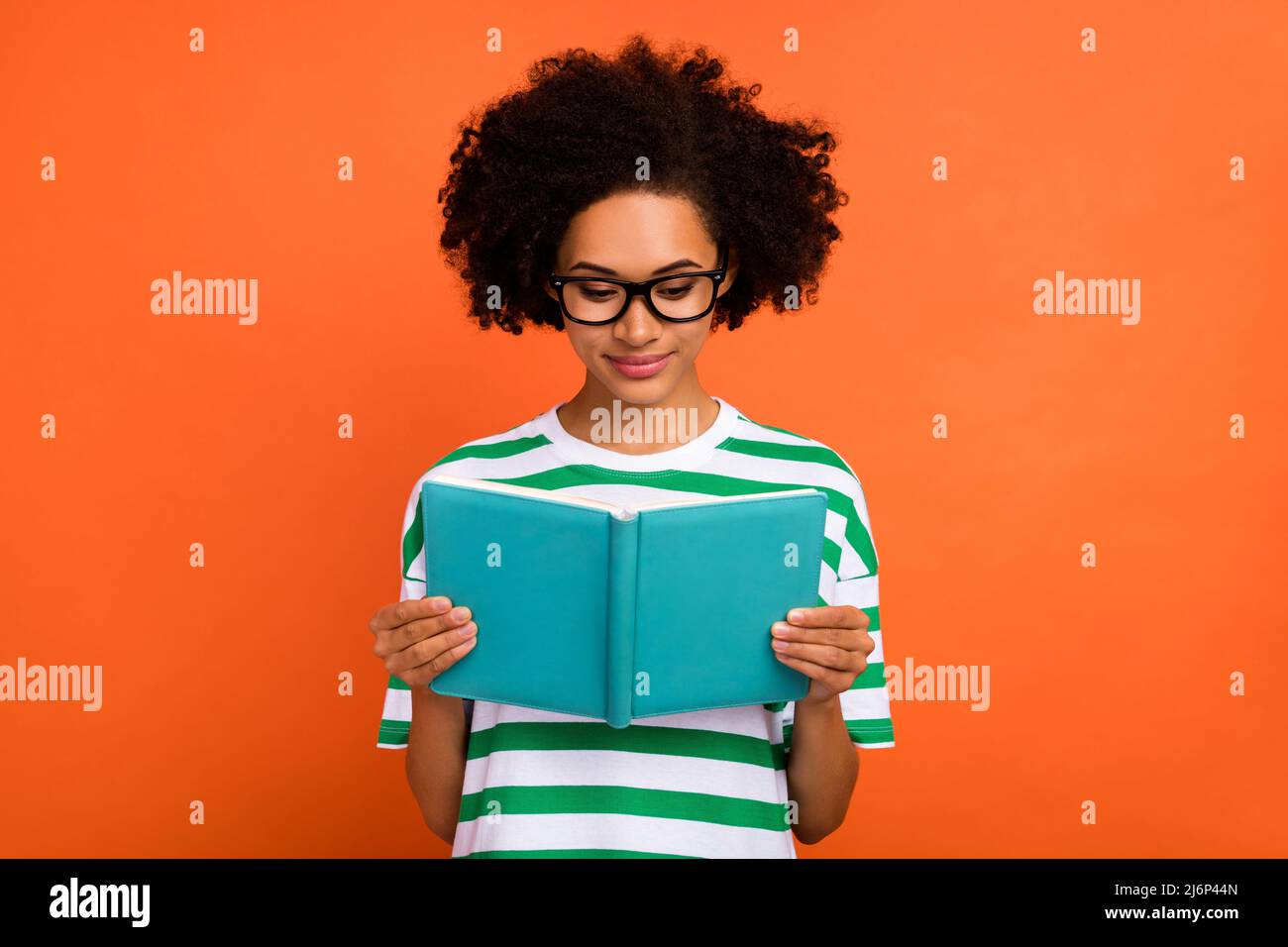 Portrait of attractive focused intellectual wavy-haired girl reading ...