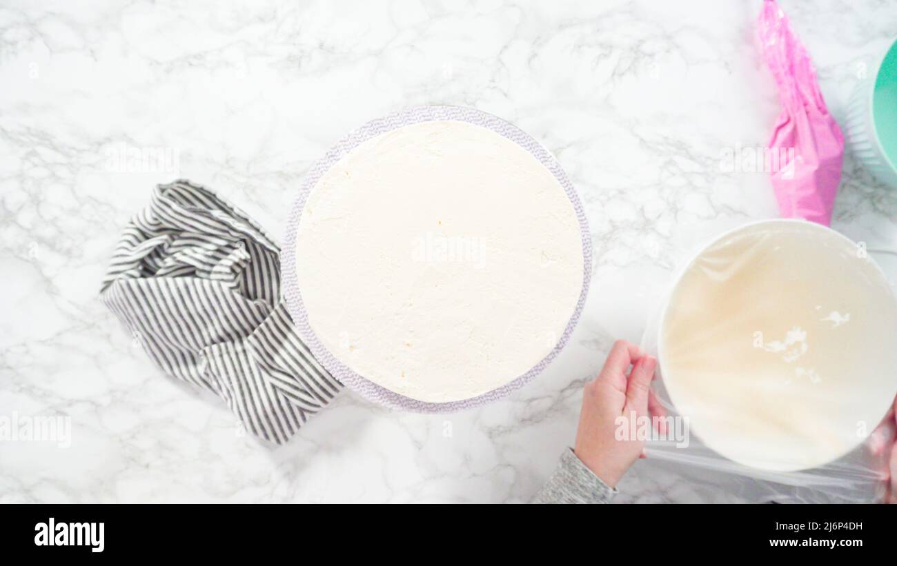 Flat lay. Step by step. Frosting round funfetti cake with white italian ...